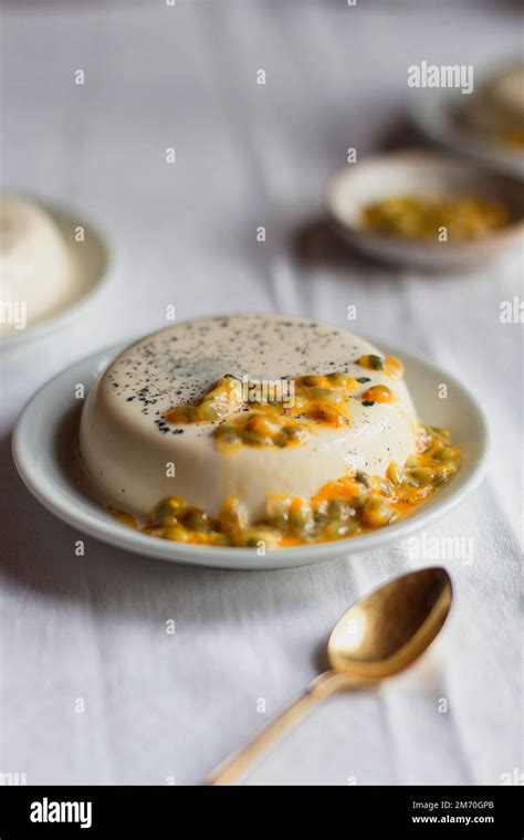 Passion Fruit Panna Cotta With Gold Spoon On A White Tablecloth Stock