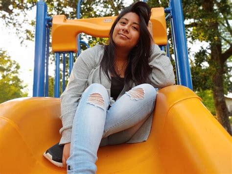 Premium Photo Portrait Of Smiling Woman Sitting On Slide At Playground
