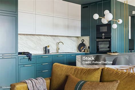 고급 현대적이고 빈티지 청록색과 흰색 주방 하얀 오웬 샹들리에가있는 대리석 부엌 섬 대리석 테이블 상단에 금으로 탭하십시오 템플렛 이동식 조리대에 대한 스톡 사진 및 기타