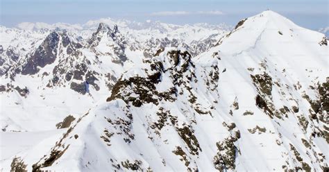한 남자 오지 스키어가 스위스 알프스의 길고 노출된 좁은 눈 능선을 오르고 하이킹을 하며 실브레타 산맥의 높은 산봉우리로 향한다 사진 Unsplash의 등산가 이미지