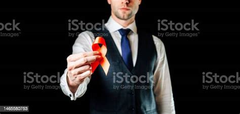Hiv 에이즈 어두운 배경에 고립 된 Hiv 세계 의 날에 빨간 리본 인식 보조 제와 암 기호를 들고 남자 건강 의료 표지판