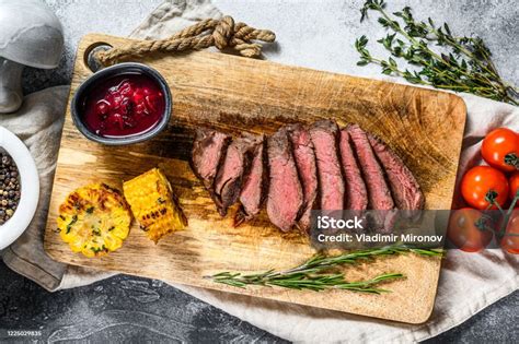 나무 도마위에 얇게 구운 필레 미뇽 스테이크 쇠고기 안심 회색 배경입니다 맨 위 보기 겉만 태우기에 대한 스톡 사진 및 기타