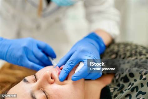입술 확대 입술에 대한 미용 주사를 받고 여자의사 미용사 미용실에서 아름다운 여자의 입술 확대 절차를 만든다 2명에 대한 스톡