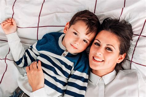 Young Mom Having Great Time With Her Son In Bed Playing Around And
