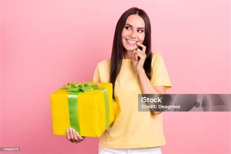 까다로운 교활한 아가씨가 선물 상자 손가락 입술을 들고 노란색 티셔츠를 입고 빈 공간을 격리 된 핑크 색 배경으로 보는 사진 30 34세에 대한 스톡 사진 및 기타 이미지