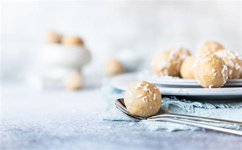 전통적인 인도 축제 과자 Laddoo 또는 Laddu는 나무 보드 밝은 배경에 코코넛 플레이크를 곁들입니다 인도에서 인기있는