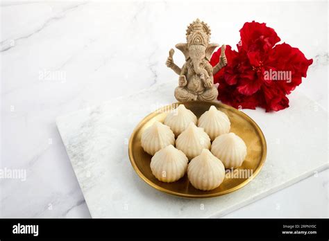 Idol Of Lord Ganesha With Modak Sweet Dish And Flower Ganesh Chaturthi