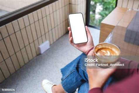커피 컵이있는 빈 데스크톱 화면이있는 휴대 전화를 들고있는 손의 모형 이미지 35 39세에 대한 스톡 사진 및 기타 이미지