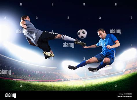 Two Soccer Players In Mid Air Kicking The Soccer Ball Stadium Lights