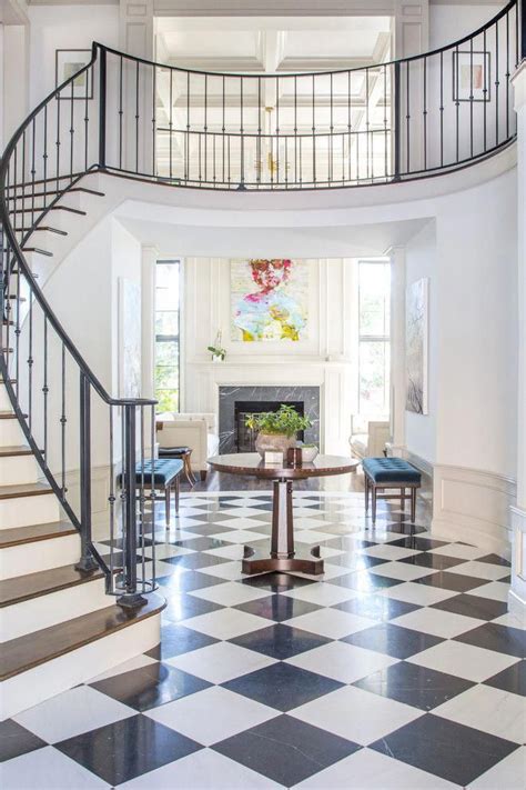 Two Story Foyer With Black And White Tiles Curved Stairway Fireplace