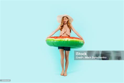 수영복과 여름 모자를 쓰고 파란 배경에 풍선 수영 원을 들고 포즈를 취하는 흥분한 행복한 소녀 공기 주입에 대한 스톡 사진 및 기타 이미지 Istock