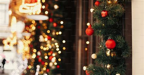 황금빛 조명이 있는 세련된 크리스마스 전나무 가지 도시 거리의 휴가 시장에서 창가에 있는 빨간 축제 싸구려 크리스마스 거리 장식입니다 텍스트를 위한 공간입니다 사진