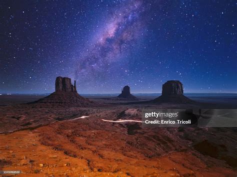 View Of The 3 Monoliths Of Monument Valley At Night With Starry Sky And