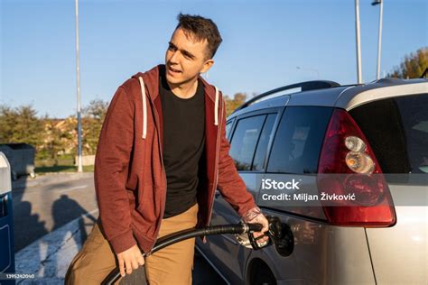 백인 남자 는 측면 복사 공간을 찾고 가격 위기 동안 셀프 서비스 주유소에서 차량에 석유를 급유 연료 탱크에 가솔린을 붓는 검은 가스 펌프 노즐을 개최 생물 연료에 대한