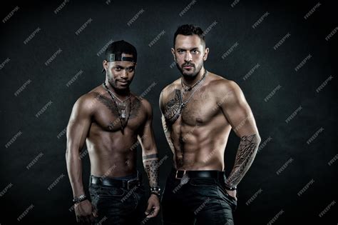 Los Machos Con Torsos Musculosos Tatuados Lucen Un Fondo Oscuro