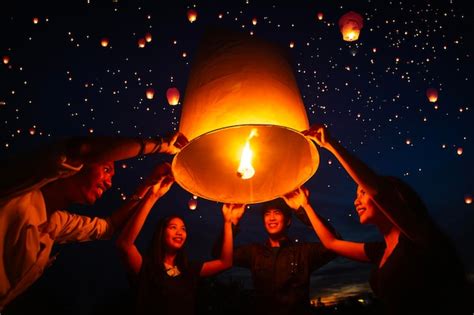 아시아 커플 여행자가 치앙마이에서 열린 로이 크라통 축제 축하 행사에서 이펭 랜턴을 설정하고 있습니다 프리미엄 사진