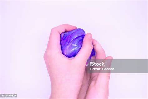 흰색 배경에 누군가 손에 두 가지 색상 파란색과 분홍색 점액과 게임의 클로즈업 점액은 분쇄되고 늘어나고 찢어지고 손으로