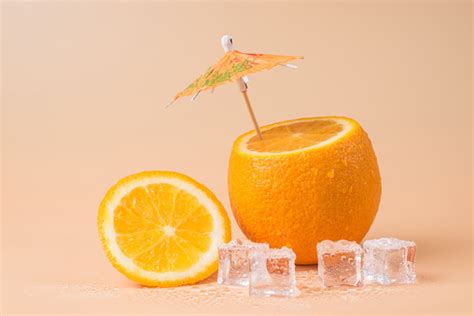 칵테일 우산을 곁들인 컷 오렌지와 모래 배경에 고립된 얼음 조각의 클로즈업 사진 각얼음에 대한 스톡 사진 및 기타 이미지 각얼음 감귤류 과일 건강한 식생활 Istock