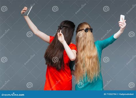 2 женщины покрыли сторону с длинными волосами и Selfie принимать