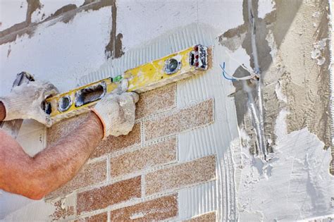 Spirit Level Is Used For Determining Horizontal Level Of Faux Brick Panel Glued To Wall Of