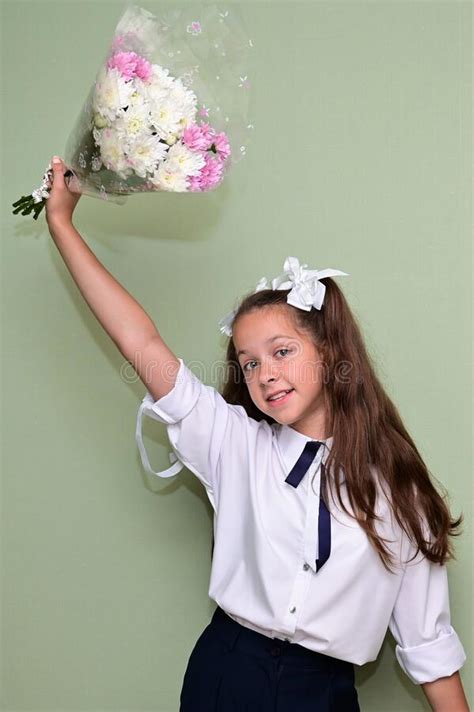 Portrait Of Pretty Girl With White Bows In Her Hair And With Bouquet Of
