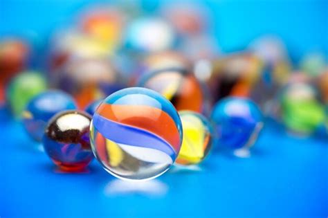 Premium Photo Close Up Of Multi Colored Marbles On Blue Table