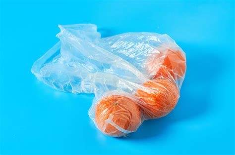 파란 배경에 폴리에틸렌 백에 담긴 신선한 통 만다린 또는 오렌지 과일 구매 개념입니다 클로즈업 Mandarin Orange에
