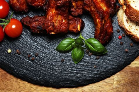 여름 Bbq에서 매운 뜨거운 구운 여분의 갈비는 빈티지 커팅 보드에 신선한 토마토와 함께 제공 0명에 대한 스톡 사진 및 기타
