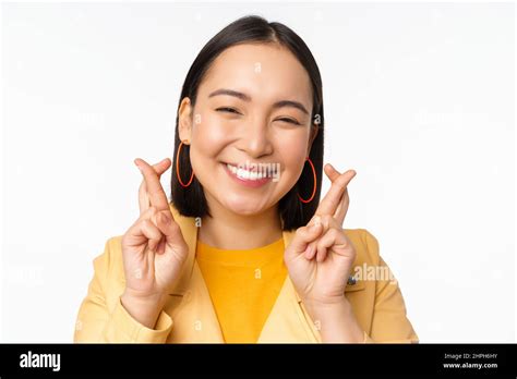 Close Up Portrait Of Hopeful Asian Girl Wishing Cross Fingers For Good