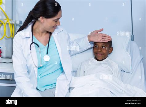 Female Doctor Checking Fever Of Patient Stock Photo Alamy