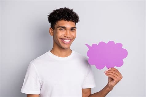 사진 브루넷 낙관적 곱슬 곱슬 한 펑키 남자의 사진 보유 거품 착용 흰색 티셔츠 에 회색 색상 배경 T 셔츠에 대한 스톡 사진