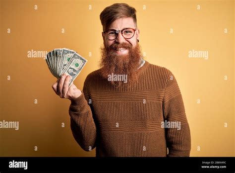 Redhead Irish Man With Beard Holding A Bunch Of 1 Dolla Banknotes Over