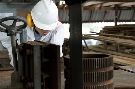 목공 공장에서 수직 띠 톱 기계에 나무 조각을 절단 하는 안전 장비와 유니폼에 젊은 노동자를 닫습니다 강철에 대한 스톡 사진 및