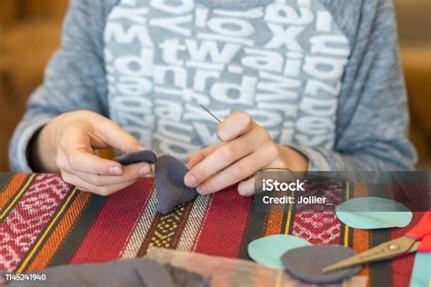 바늘과 실을 가진 어린 소녀 만들기 펠트로 만든 꼬마 소녀 만들기 펠트로 만든 꼬마 소녀 어린 소녀는 회색 마우스를 세운 어린 소녀를 세우는 장난감 겨울에 대한 스톡 사진