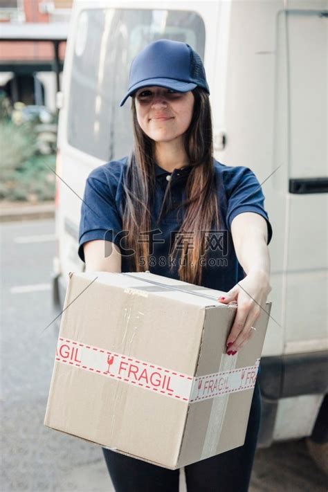 拿着纸箱的微笑女快递员肖像高清摄影大图 千库网