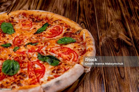 맛있는 향기로운 피자 모짜렐라 토마토 및 바질과 함께 토마토 소스에 바질이 들어간 Margherita가 배경에 있습니다 공간