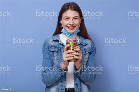 의료 용 마스크를 착용 하는 아름 다운 소녀의 초상화를 닫고 세계에서 뜨거운 음료 코로나 바이러스 발발 글로벌 전염병 감염