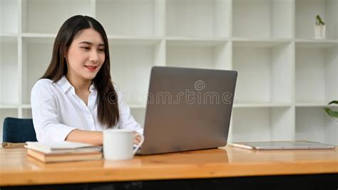 Asian Businesswoman Or Female Assistant Using Laptop Computer Focused