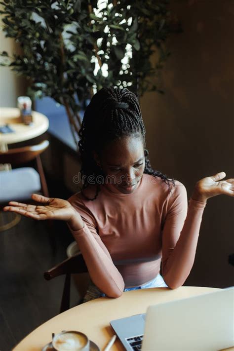 Young Irritated African American Woman Sit At Table Looking At Screen