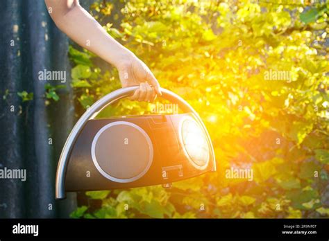 A Hand Holds A Retro Boombox Creating A Nostalgic Scene Against A