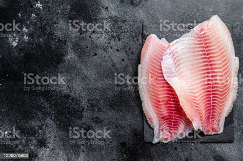 도마에 텔라피아의 원시 필렛 검은 색 배경입니다 맨 위 보기 복사 공간 건강한 식생활에 대한 스톡 사진 및 기타 이미지