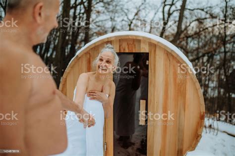 추운 겨울날 야외 사우나에서 나오는 남편과 함께 수건을 입은 노인 여성 사우나에 대한 스톡 사진 및 기타 이미지 사우나