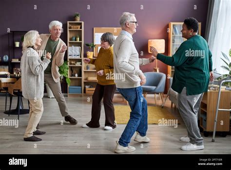 Full Length View At Group Of Senior People Dancing In Retirement Home