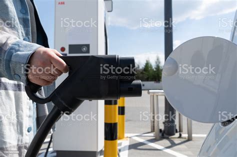 Ev 자동차 충전소에서 전기 자동차용 고속 충전 소켓 유형 2 플러그를 들고 있는 여성 배터리 충전기에 대한 스톡 사진 및 기타 이미지 배터리 충전기 전기 자동차 대체