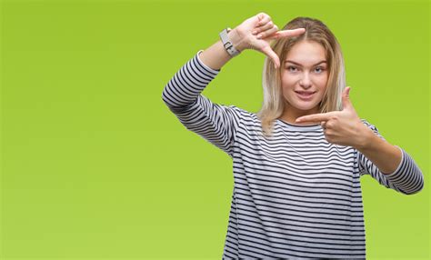 손으로 만드는 프레임 및 행복 한 얼굴로 손가락을 웃 고 고립 된 배경 위에 젊은 백인 여자 창의력과 사진 개념입니다 개념에