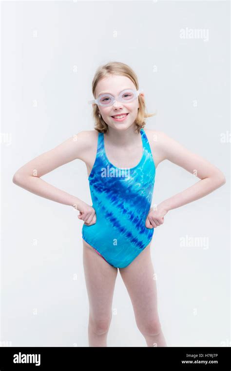 A Young Girl Wearing A Swimming Suit And Goggles Over Her Eyes Posing