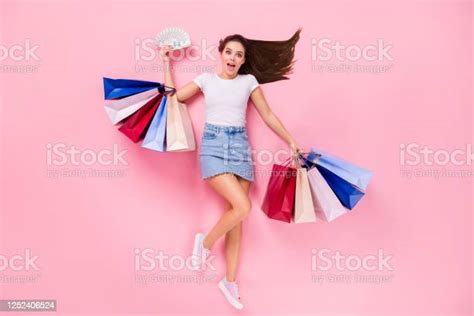 상부 높은 각도 보기 전체 길이 사진 충격 소녀 센터 클라이언트 감동 홀드 머니 팬 가방 당첨 복권 누워 짧은 미니 데님 청바지 스커트 파스텔 컬러 배경 에 격리 T 셔츠에