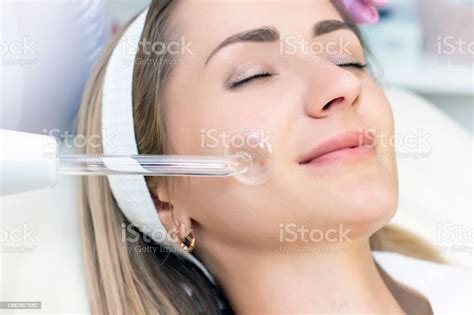 미용 학자는 젊은 여성의 얼굴에 맥박 전류 절차를 수행합니다 닫다 건강관리와 의술에 대한 스톡 사진 및 기타 이미지 건강