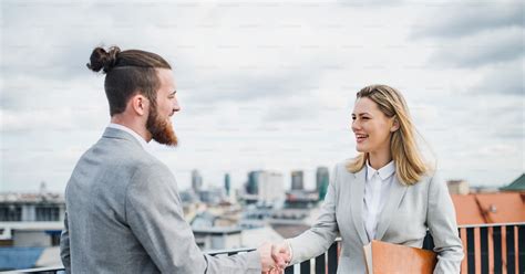 두 명의 젊은 사업가가 사무실 밖 테라스에 서서 악수를 하고 있다 사진 Unsplash의 서 이미지