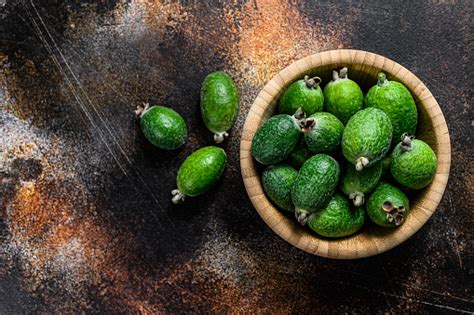 어두운 배경에 나무 접시에 녹색 Feijoa 과일 열대 과일 페이조아 맨 위 보기 텍스트를 위한 공간 0명에 대한 스톡 사진 및